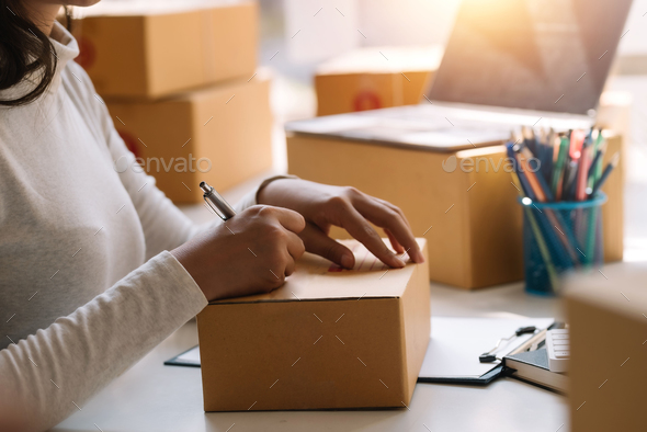 Online sales business owner woman is taking note of the customer's ...