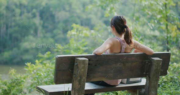 Sport woman enjoy forest lake view and sit on wooden bench Stock Photo ...