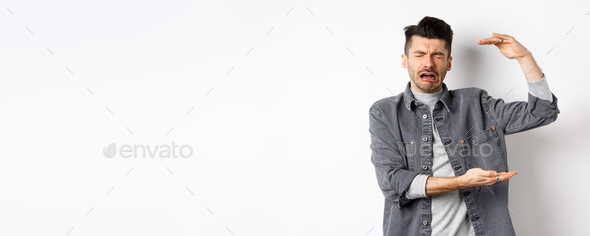 Sad man crying and showing big size object, shaping large thing and ...