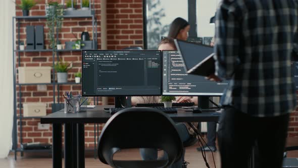 Programer Coding On Laptop Sitting Down At Desk With Computer Screens Parsing Code Stock Footage