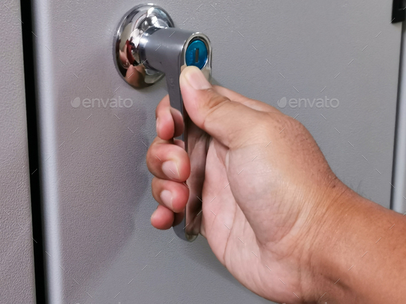 Close up photo of door handle with key on low voltage switchboard ...