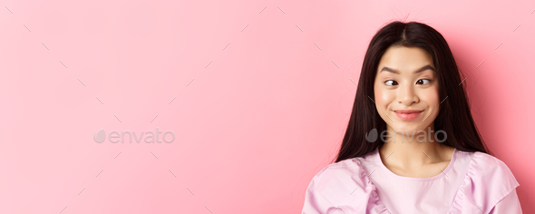 Close-up portrait of funny asian woman squinting eyes and making silly ...