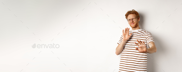Displeased young man with red hair and bristle showing stop gesture ...