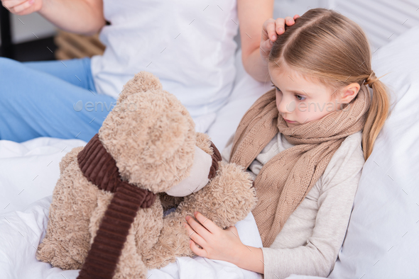 cropped image of mother taking care of sick daughter in bedroom Stock ...