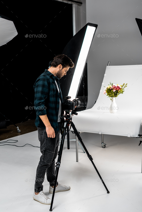handsome young photographer shooting beautiful flowers in professional ...