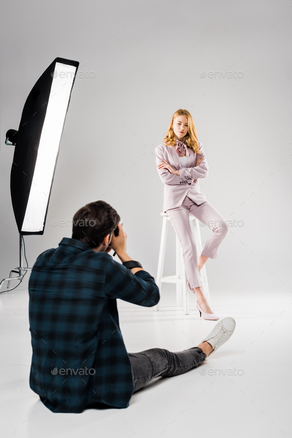 back view of photographer sitting and photographing beautiful female ...