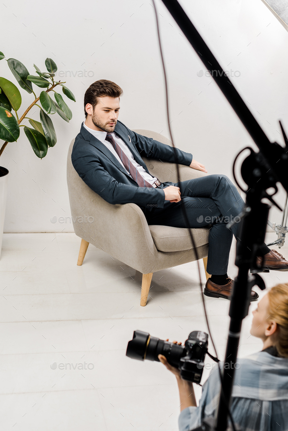 high angle view of young photographer and handsome model working ...