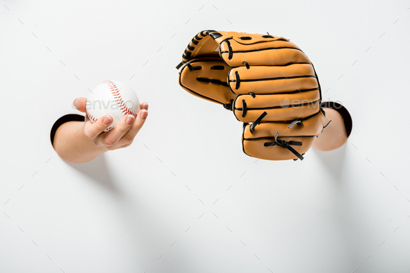 cropped image of woman holding baseball glove and ball through holes on ...