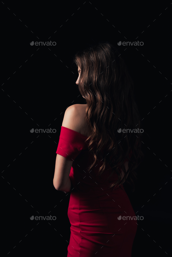 back view of woman in red dress posing isolated on black Stock Photo by ...