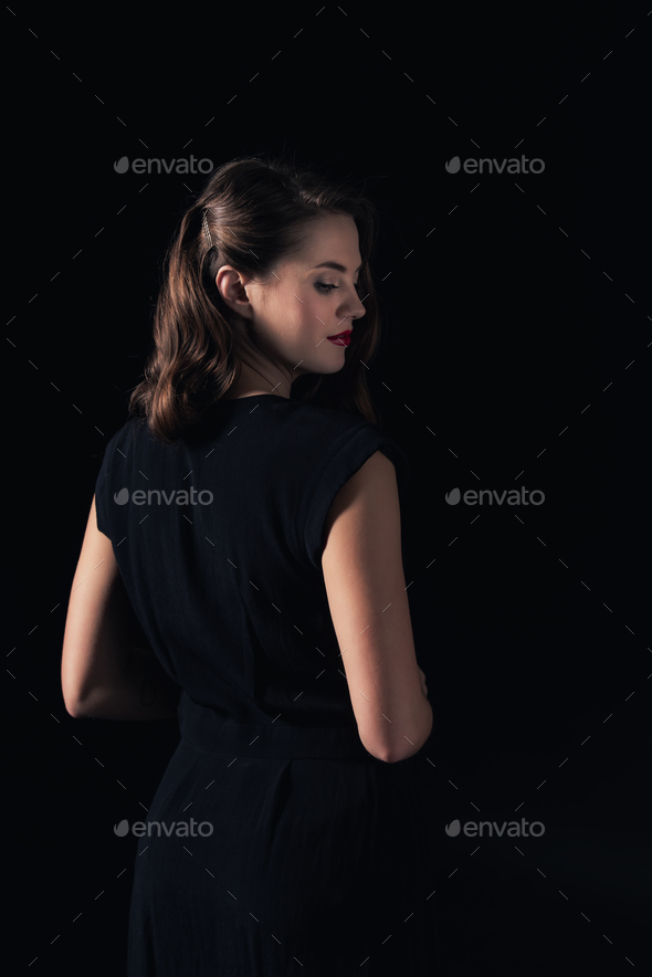 back view of beautiful woman in dress posing isolated on black Stock ...