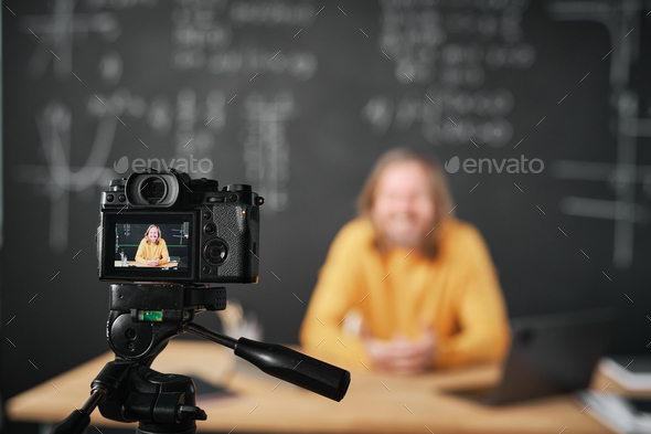 Teacher recording lesson on camera in class Stock Photo by Media_photos