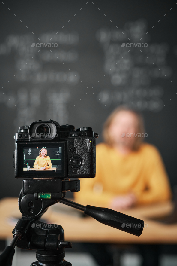 Teacher recording lesson on professional camera Stock Photo by Media_photos