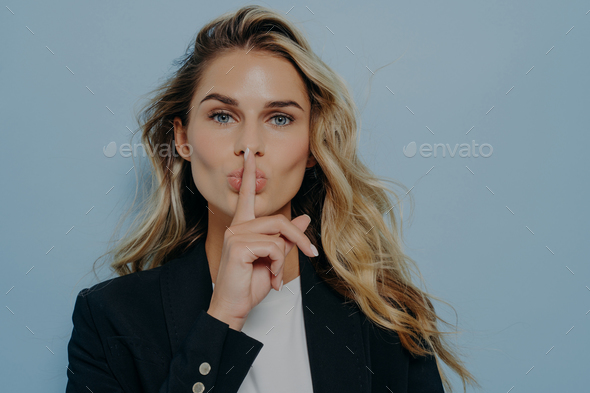 Blonde woman making shush gesture with her hand Stock Photo by StudioVK