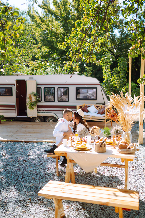 Beautiful wedding couple laugh and kiss relaxing in rv, camping in a ...