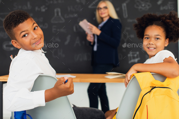 A girl and a boy, African-American school children, solve problems with ...