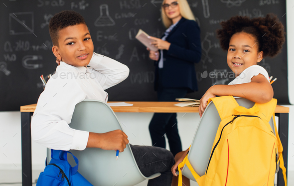 A girl and a boy, African-American school children, solve problems with ...