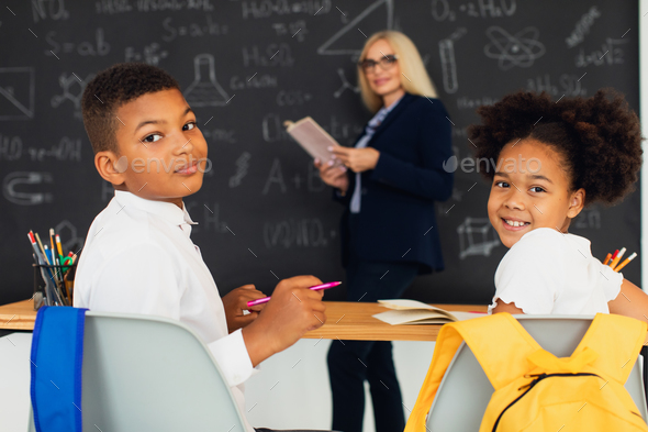 A girl and a boy, African-American school children, solve problems with ...