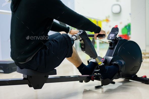 Male patient with physical disability doing exercise routine indoor ...