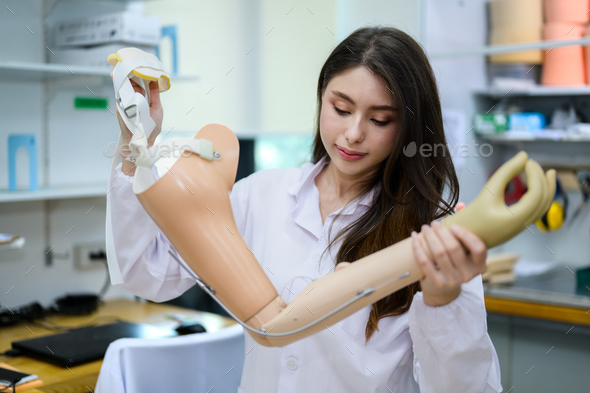 Prosthetic technician holding prosthetic arm checking and controlling ...
