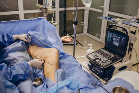 doctor and an assistant in the operating room for surgical venous ...