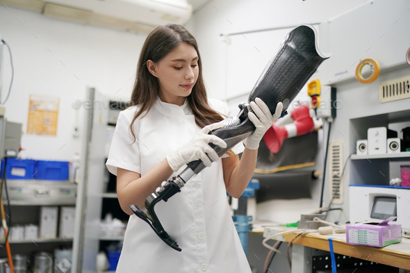 Orthopedic technician making prosthetic leg for disabilities people in ...