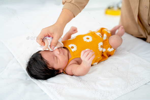 Close up mother hand use towel to clean in area of eye and face of ...