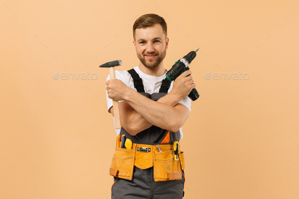 Positive male repairman at home with tools on beige background Stock ...