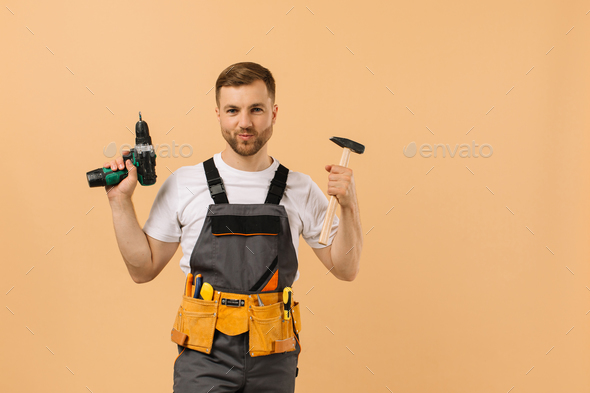 Positive male repairman at home with tools on beige background Stock ...