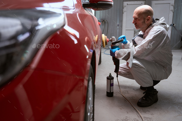 Car repairman at workplace works with body of red car Stock Photo by ...