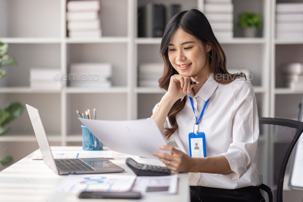 Charming Young asian businesswoman sitting on laptop computer in the ...