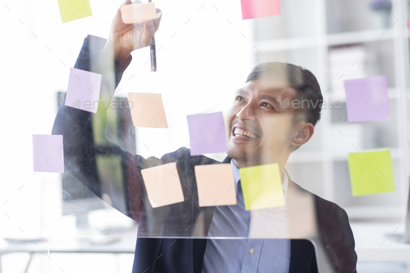 Concentrated adult business asian man, organizing his busy work week in ...