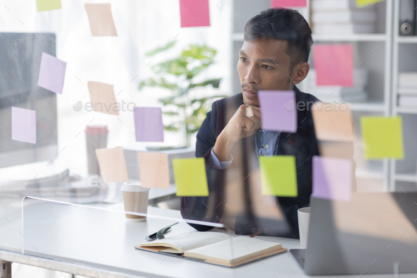 Concentrated adult business asian man, organizing his busy work week in ...