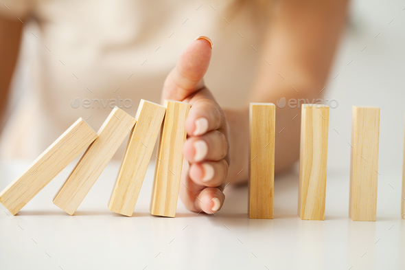 Hand of woman stopping and protect wooden block falling Stock Photo by ...