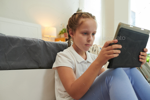 Preteen Girl Watching VIdeo on Tablet Stock Photo by DragonImages ...