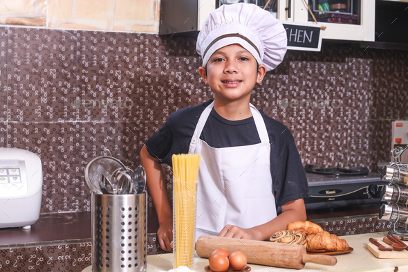 Smiling cute boy cooking bakery and pastry in the kitchen at home Stock ...