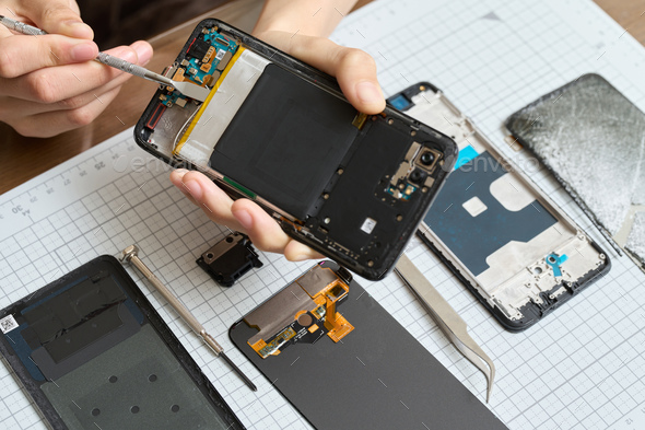 Hands performing disassembly maintenance of smartphones Stock Photo by ...