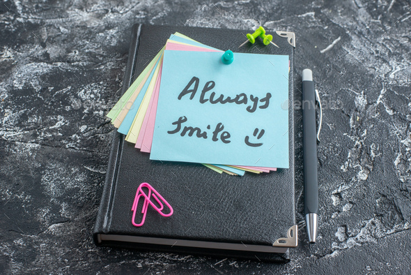 fron view always smile note with black copybook on gray background ...