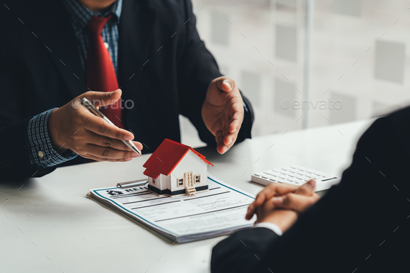 The real estate agent is explaining the house style to the clients who ...