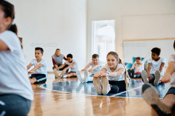 Schoolgirl and her classmates warming up during physical education ...