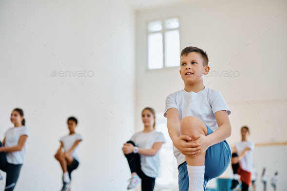 Happy student and his classmates practicing on PE class at school gym ...