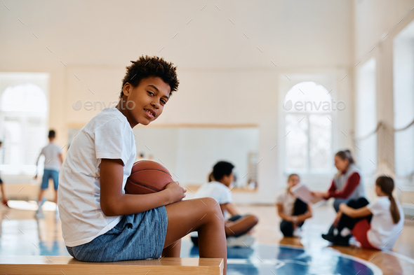Happy black schoolboy on physical education class looking at camera ...