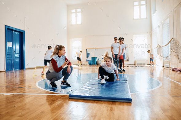 Elementary students having physical activity class with sports teacher ...