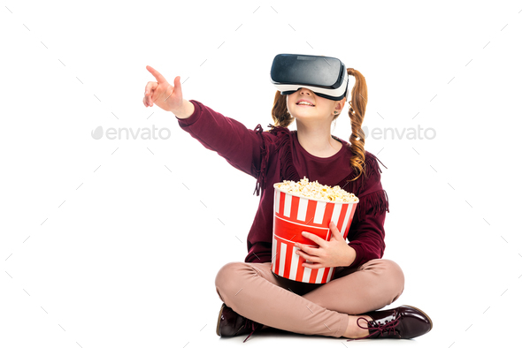 child with virtual reality headset on head holding striped popcorn ...