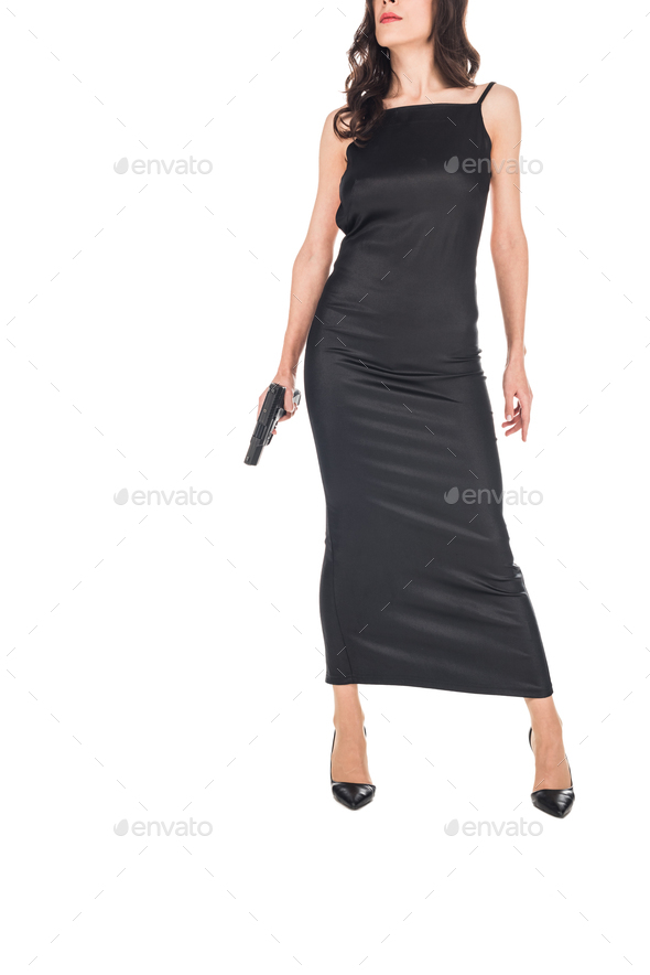 cropped view of female secret agent in black dress holding gun ...