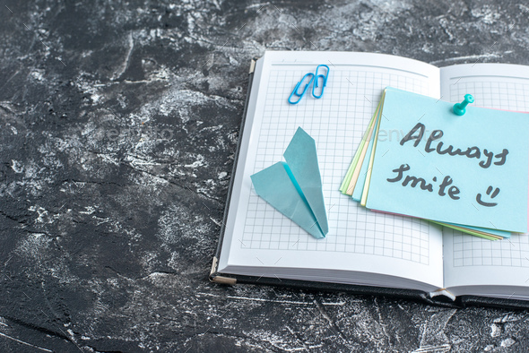 front view always smile note on open copybook on light gray background ...