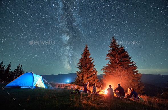 Night camping in mountains under starry sky with Milky way. Stock Photo by anatoliy_gleb