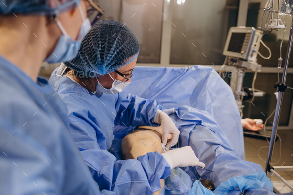 doctor and an assistant in the operating room for surgical venous ...