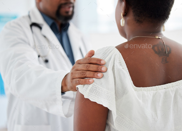 Doctor touching a patient on the shoulder in support. Closeup on hand ...