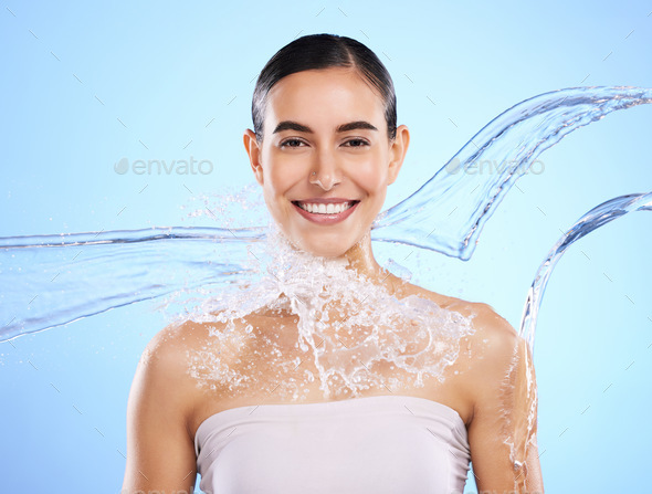 Water splash, portrait and woman shower in studio, blue background and ...