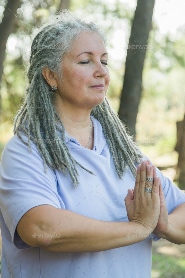 Portrait of mature woman with grey hair dreadlocks in sporty outfit ...